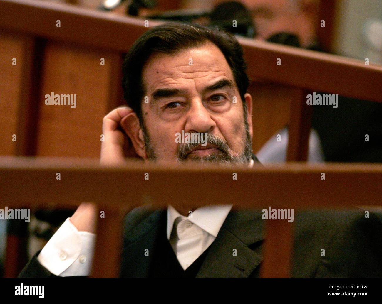 Former Iraqi President Saddam Hussein listens to the prosecution during ...
