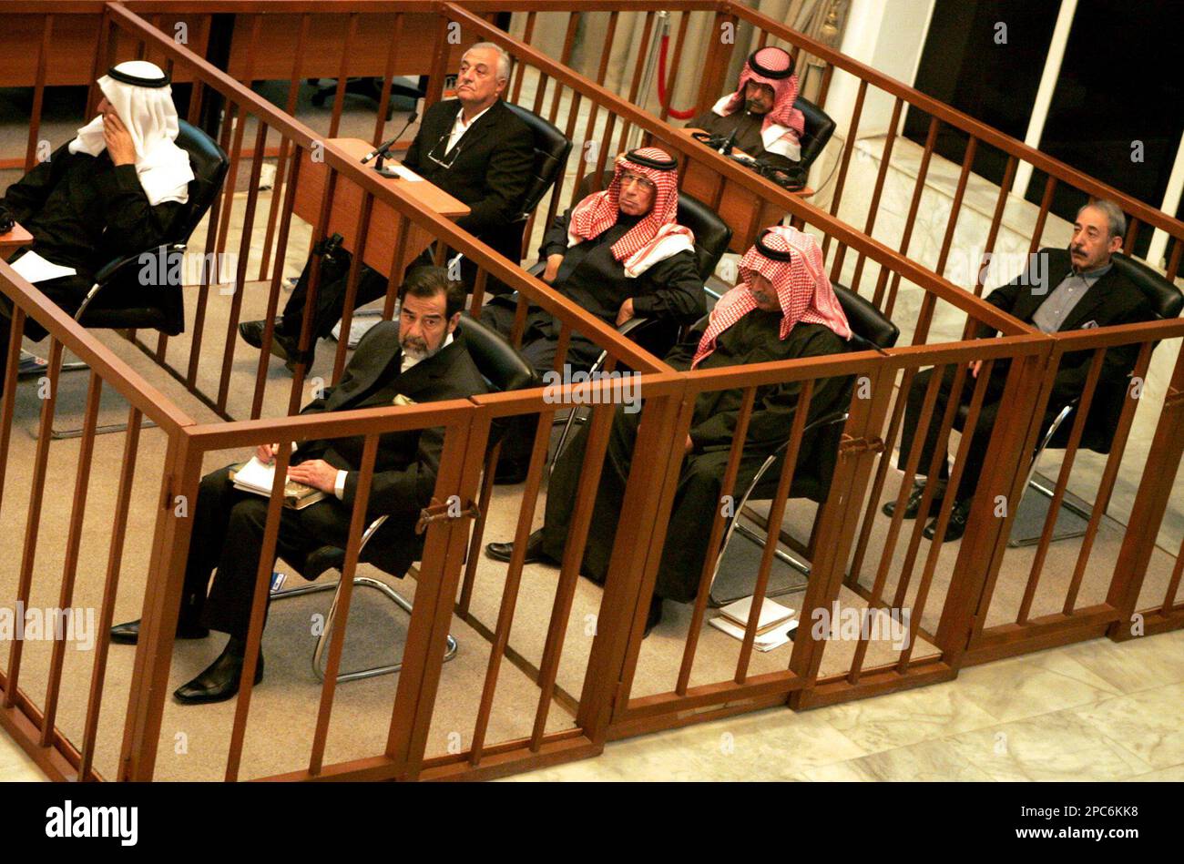 Former Iraqi President Saddam Hussein, front left, and his co-defendants sit while they listen ...