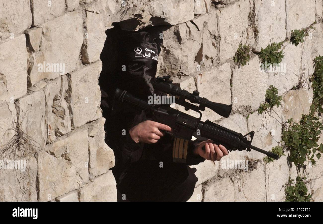 A masked Palestinian militant from the al-Aqsa Martyrs' Brigades, a ...