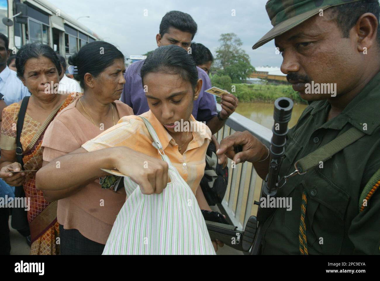 Sri Lankan government soldiers inspect the identity of commuters at a check point in Colombo ...
