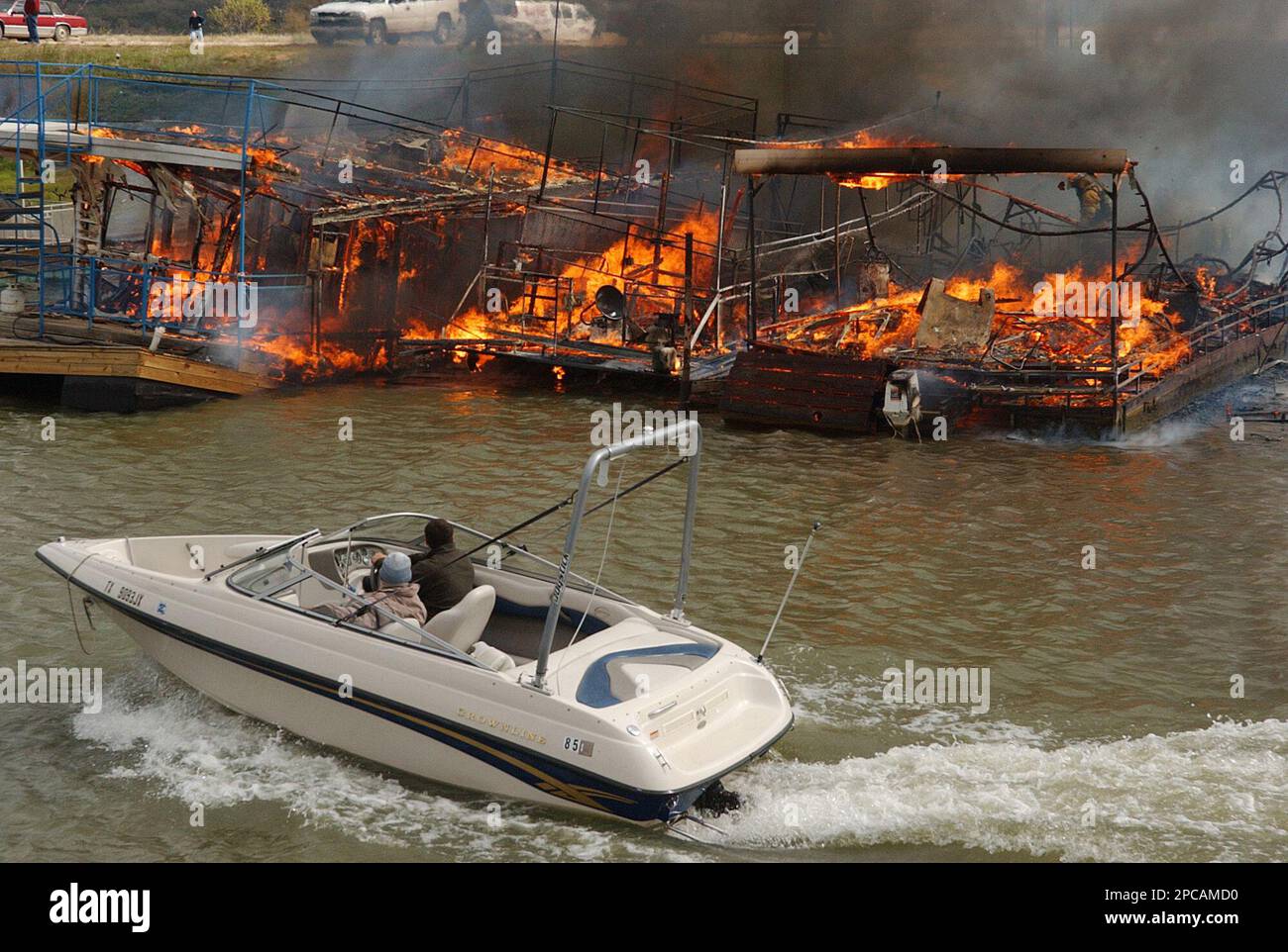 Houseboats at the Lake Waco Marina burn as a power boat passes ...