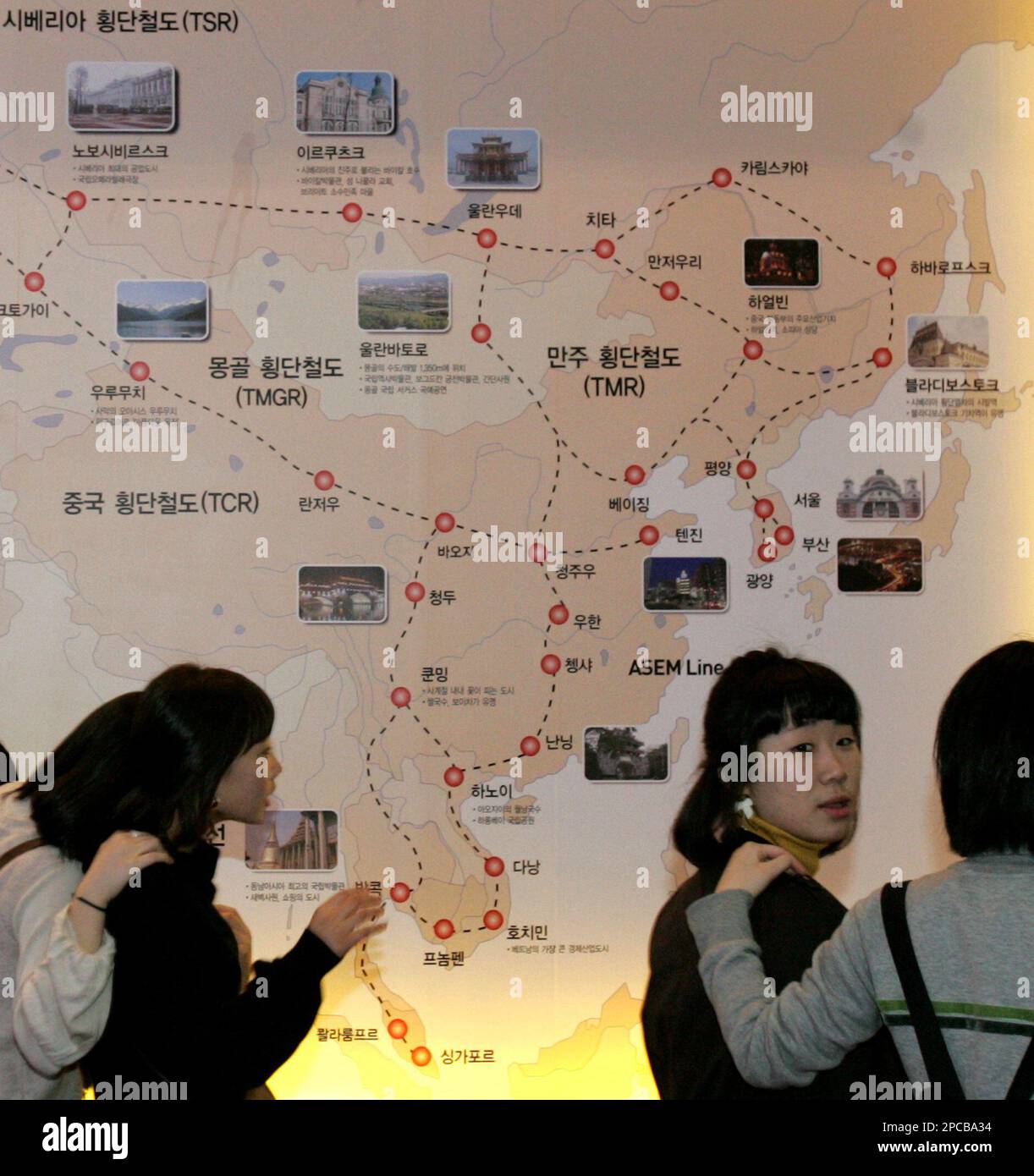 South Korean visitors look at a map showing a proposed Asian railway ...