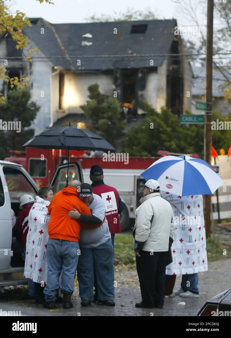 Family and friends of the victims console each other at the scene of a ...