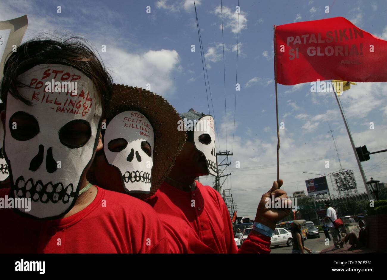 Protesters wearing skull masks display an "Oust Gloria" flag as they ...
