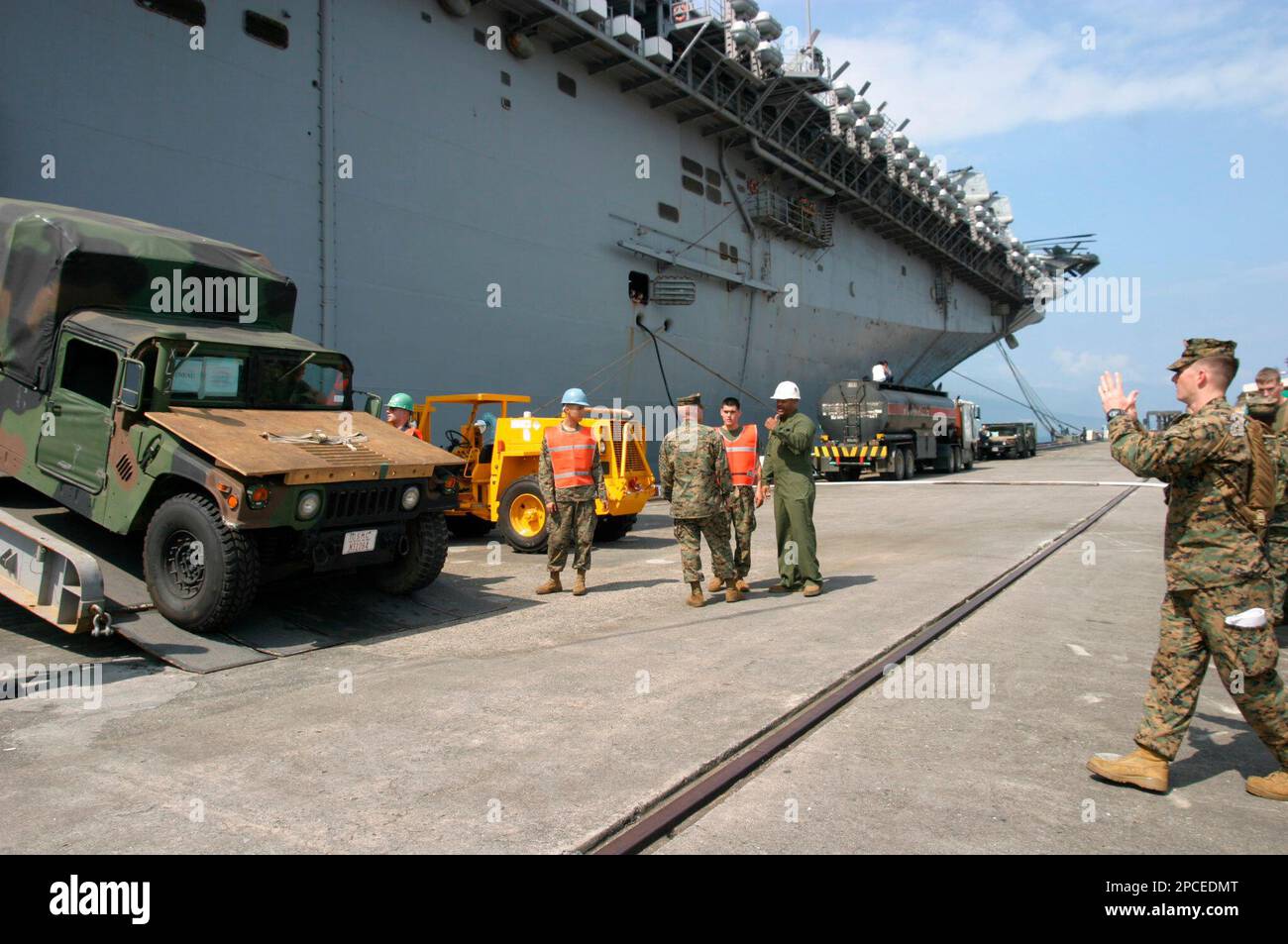 A U.S. Marine guides a disembarking humvee from the the amphibious ...