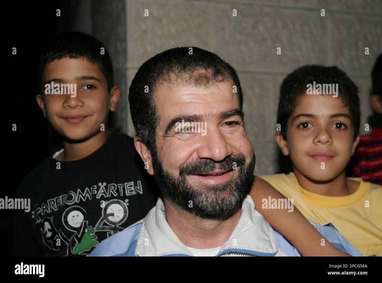 Jordanian lawmaker Ali Abul Sukkar, center, smiles with his sons Jehad ...