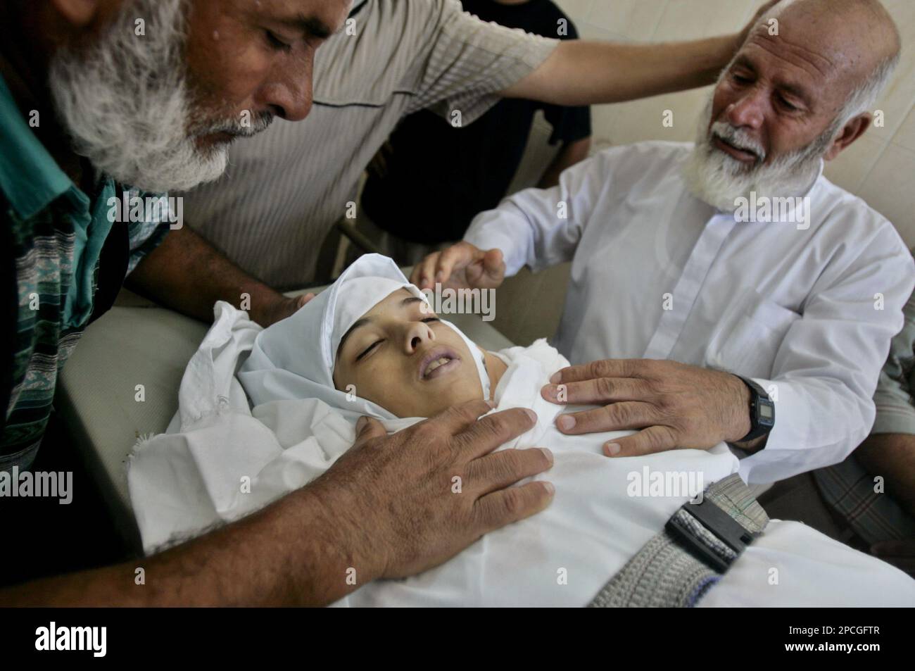 Relatives of the 14 year-old girl, Ram el Iz Hammad, prepare her body ...