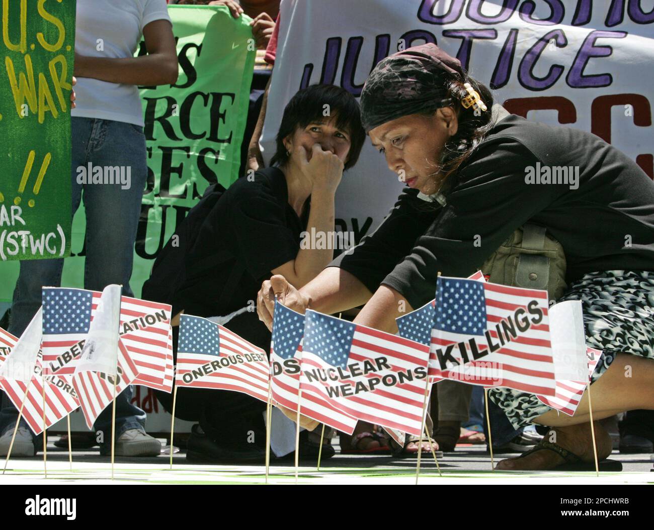 A protester plants altered American flags with the listing of alleged U ...