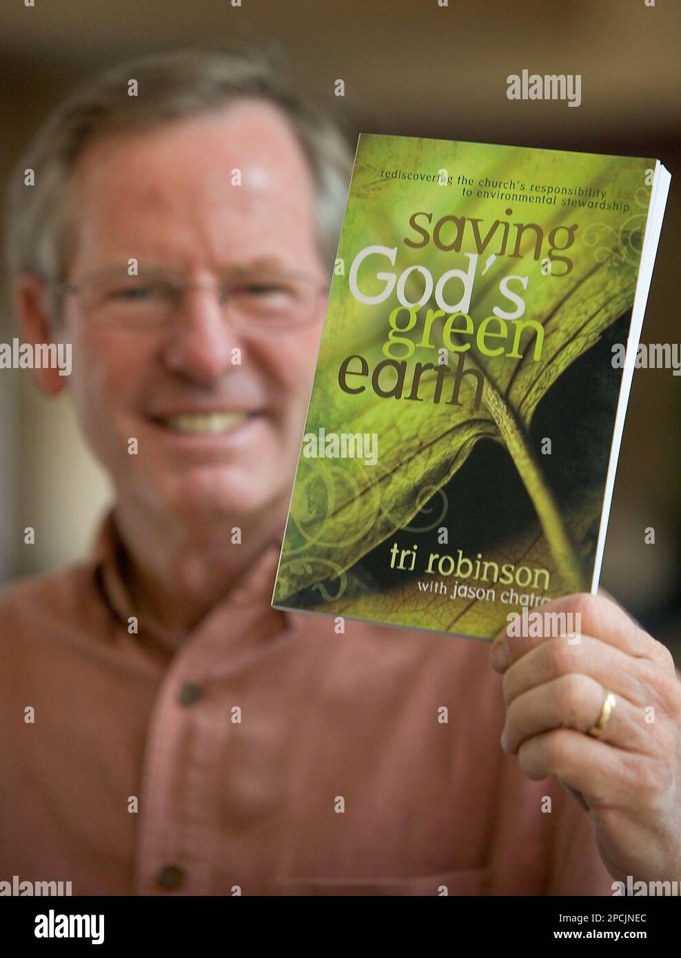 Vineyard Christian Fellowship's Tri Robinson holds up a book he wrote ...