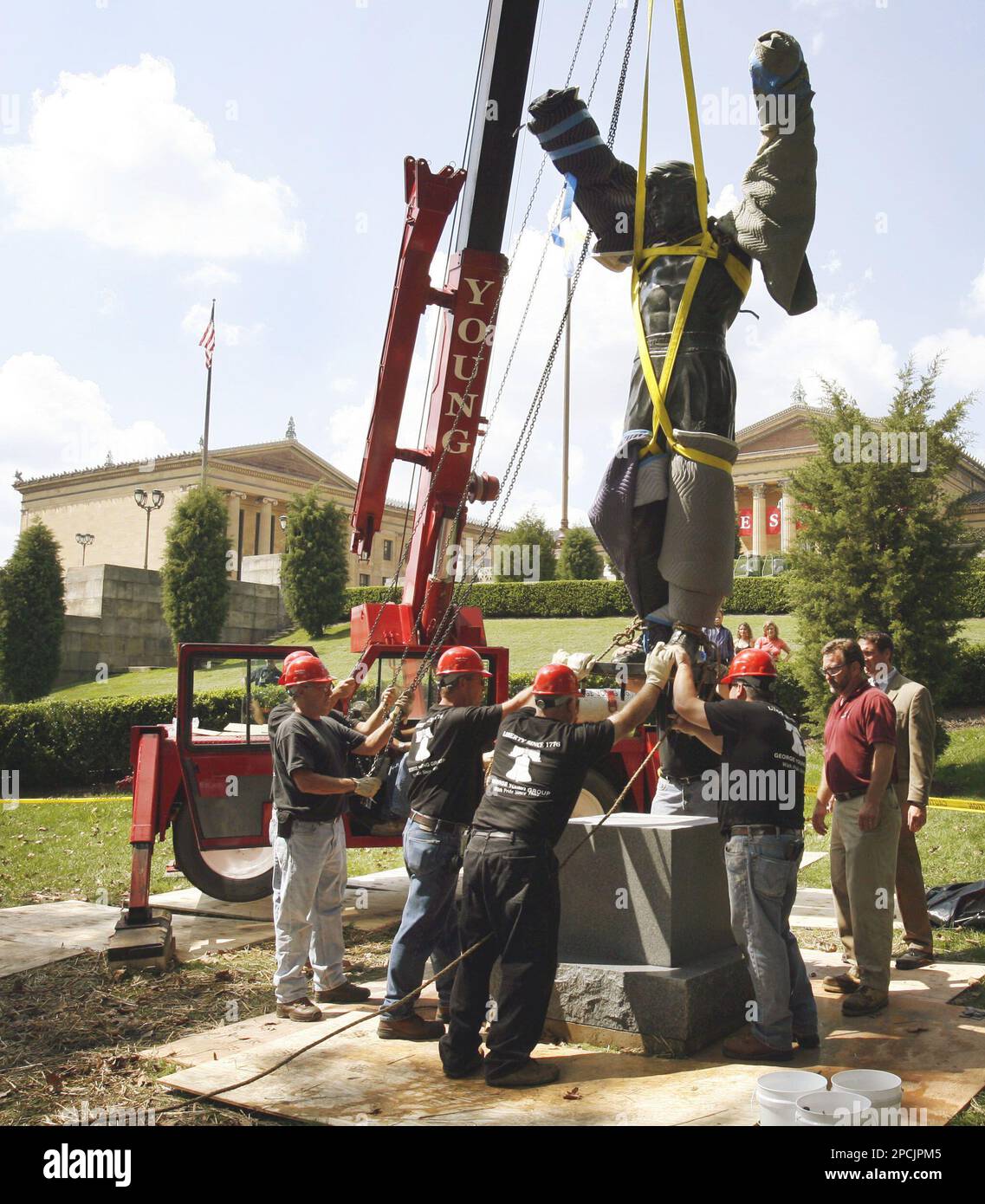 Workers install a bronze statue of Sylvester Stallone portraying the ...