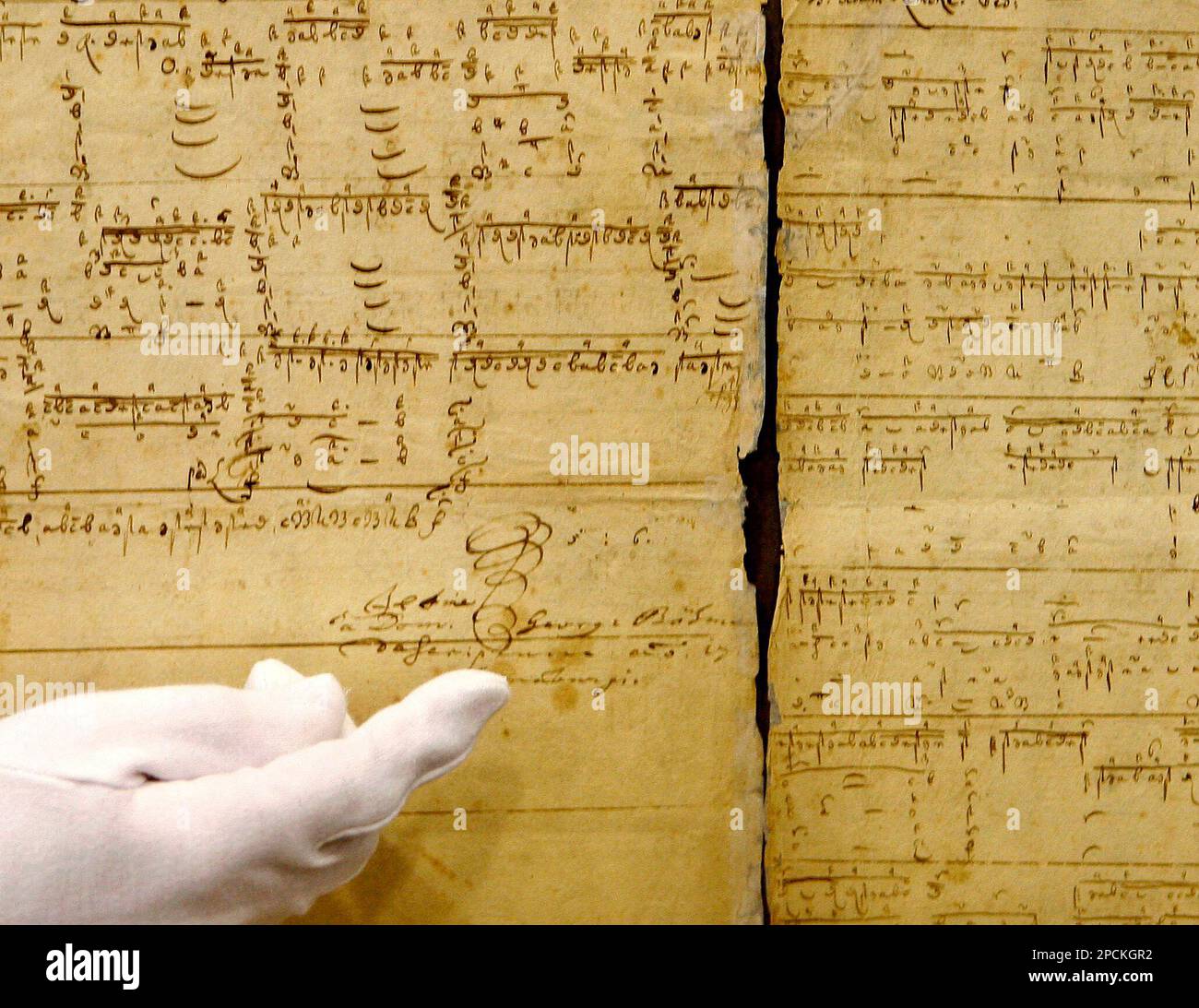 Die Hand einer Restauratorin zeigt auf die Unterschrift Johann ...