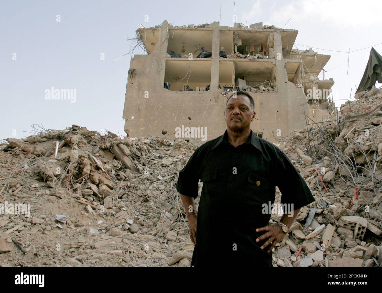 Veteran US civil rights leader Rev. Jesse Jackson stands on the rubble ...