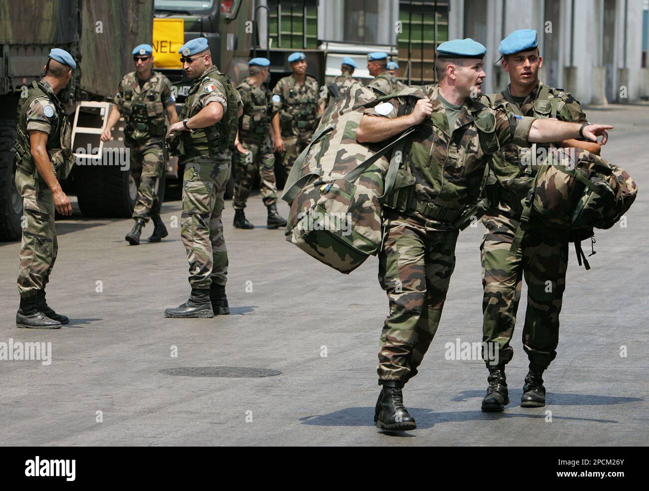 United Nations peacekeepers from France carry bags after they disembark ...