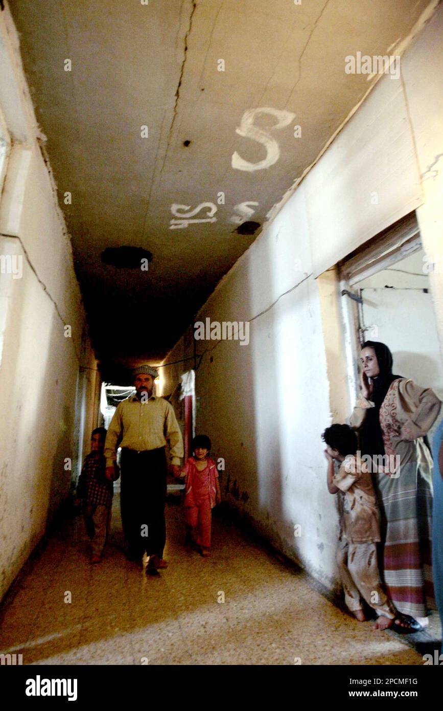 An Iraqi Kurdish family lives in a damaged building, which was used by Saddam Hussein's Army to ...