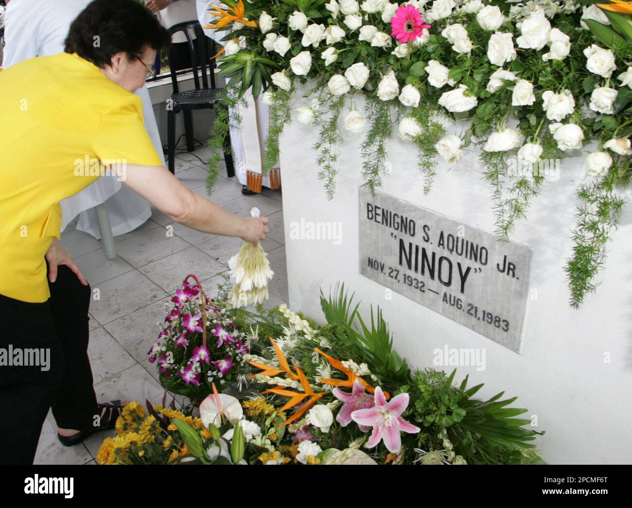 Former Philippine President Corazon Aquino places flowers given by ...