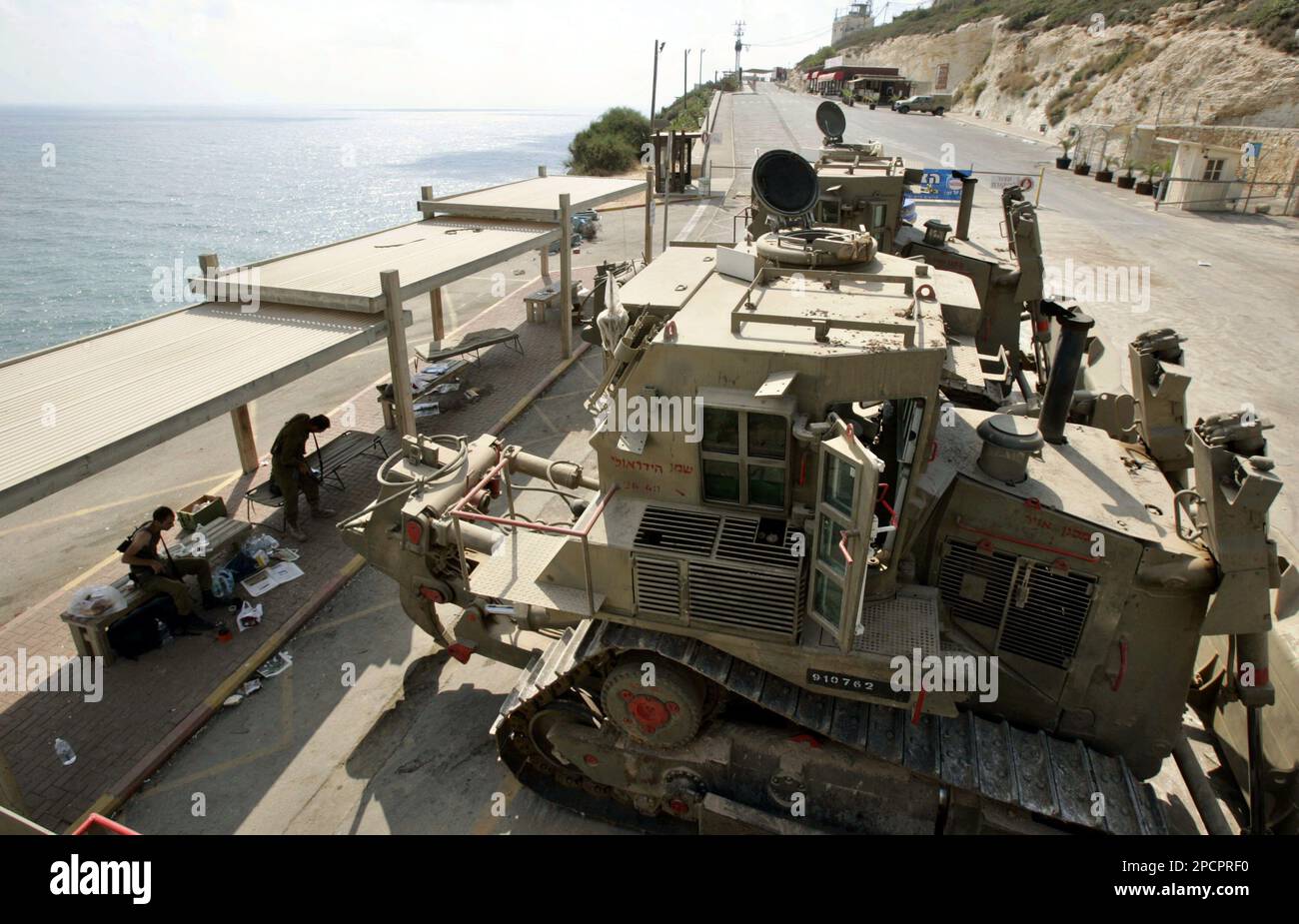 Israeli soldiers rest next to armored bulldozer in northern Israel ...