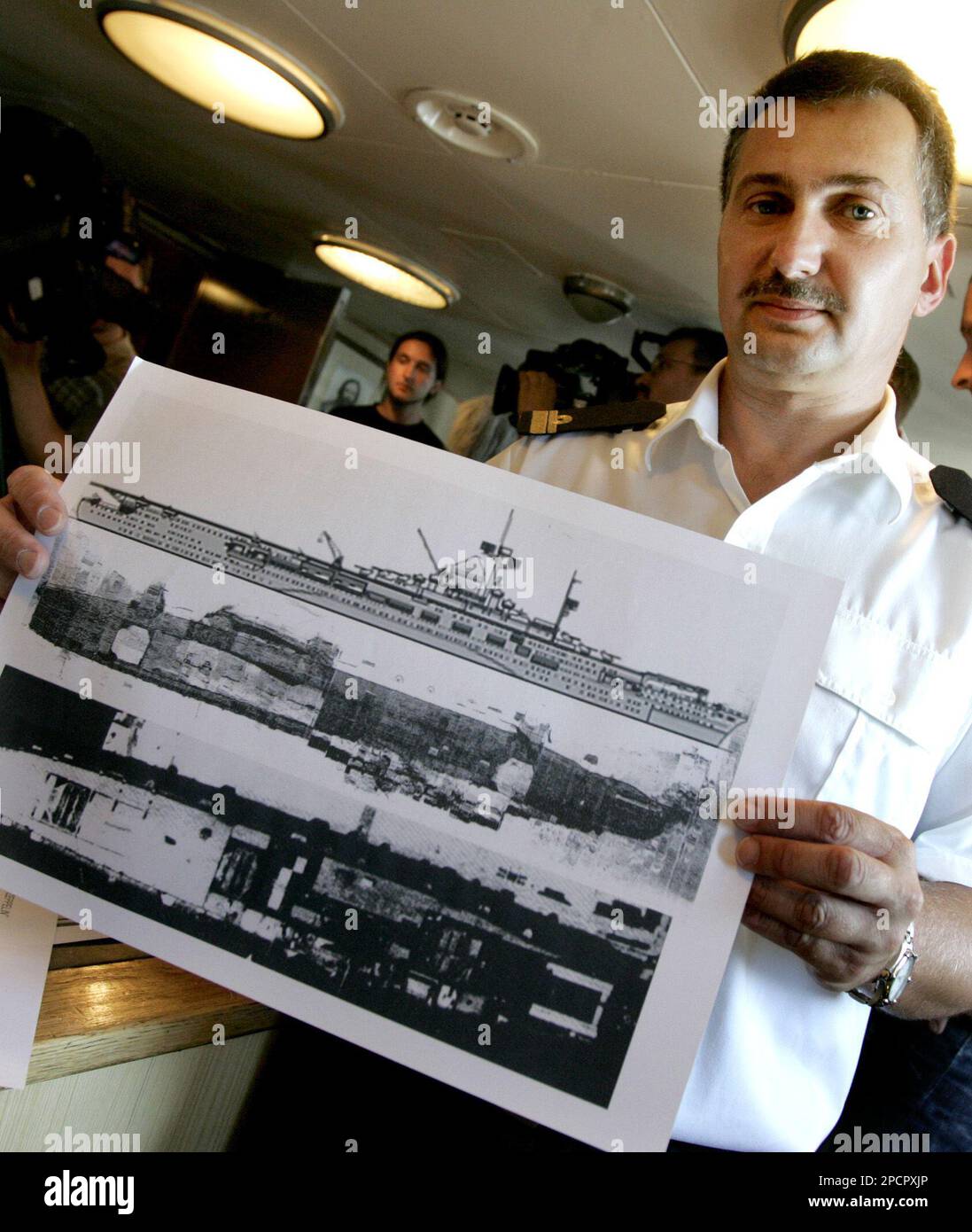 Polish Navy Commander Dariusz Beczek holds up an images showing with ...