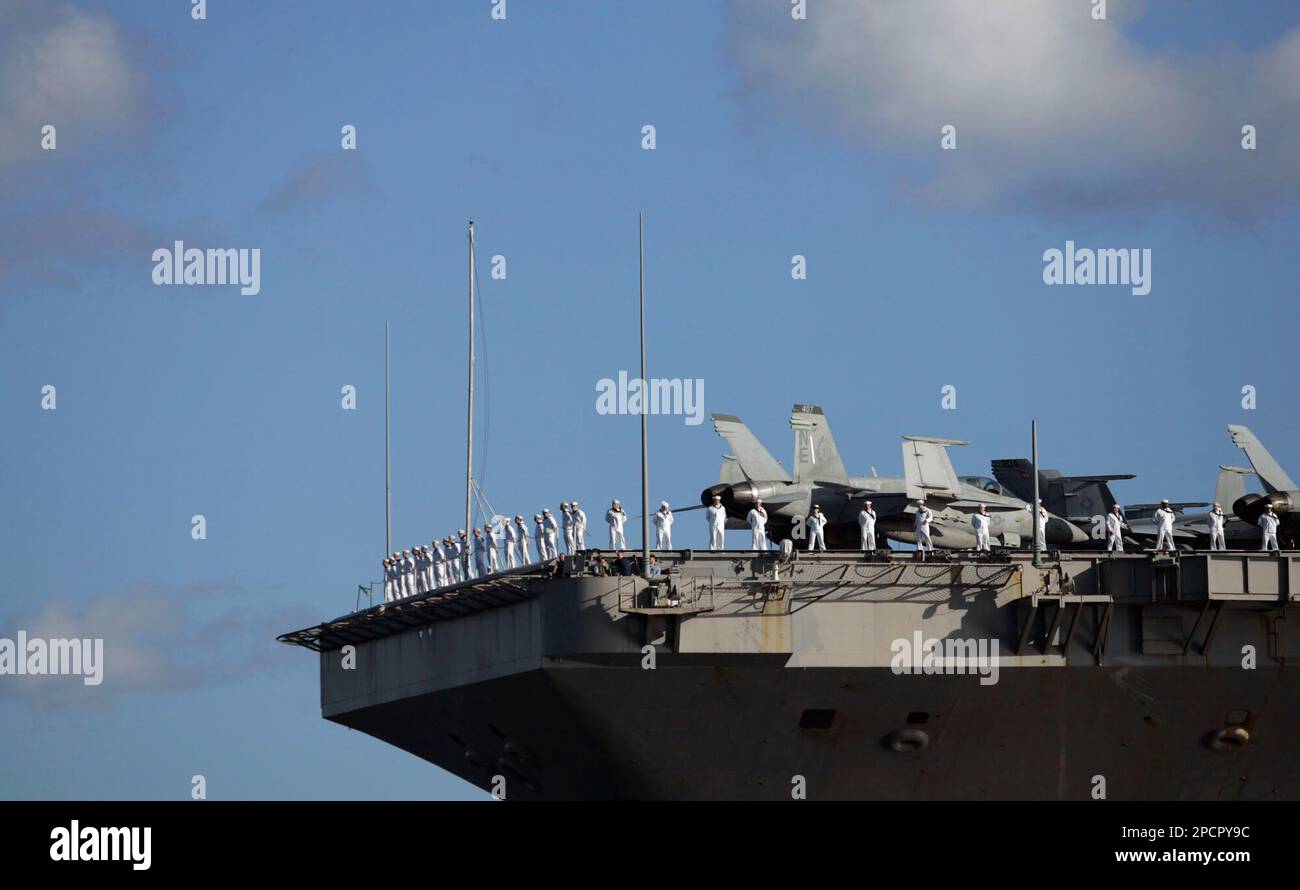 US Navy seaman stand at attention on the deck of the USS Abraham ...