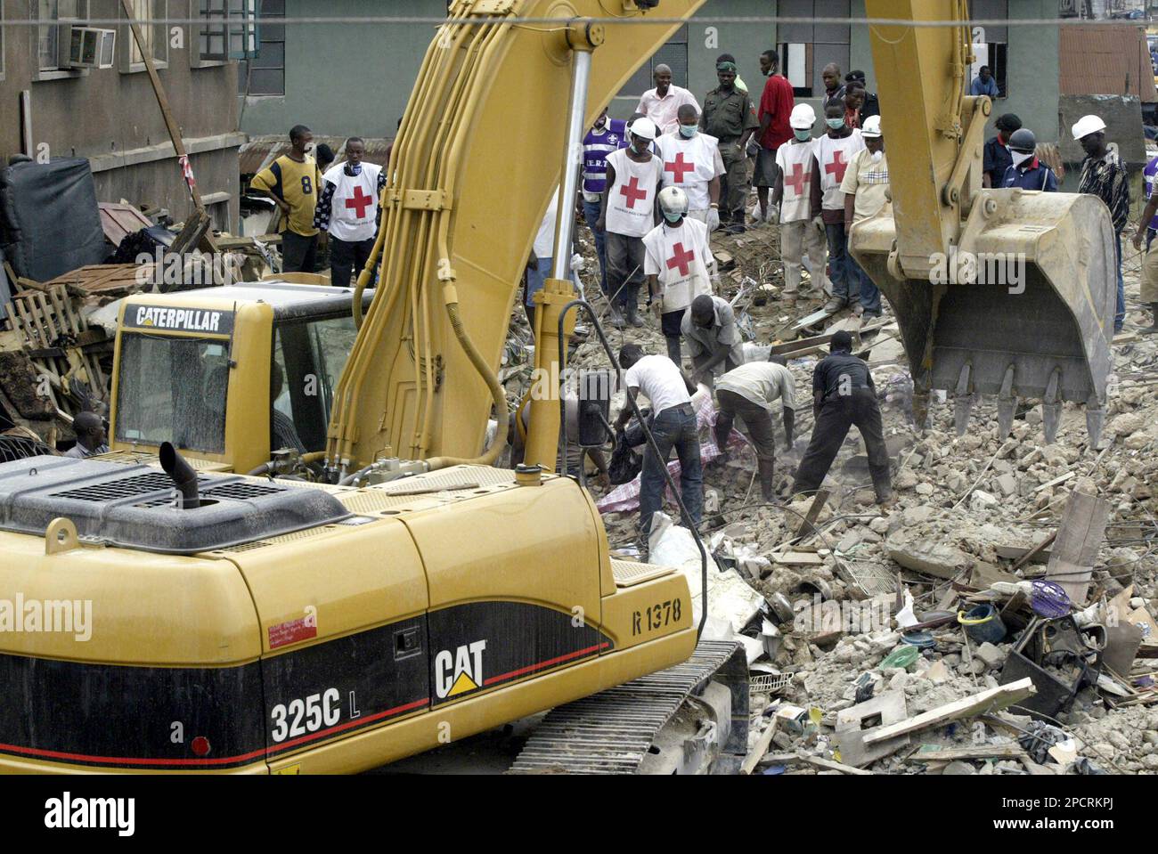 Red Cross rescue workers search for more dead bodies from the rubble of ...