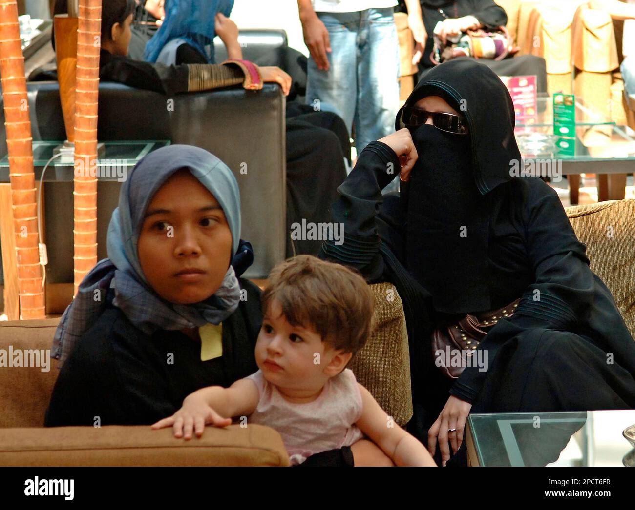 A Saudi tourist waits with her baby and foreign workers to be evacuated ...