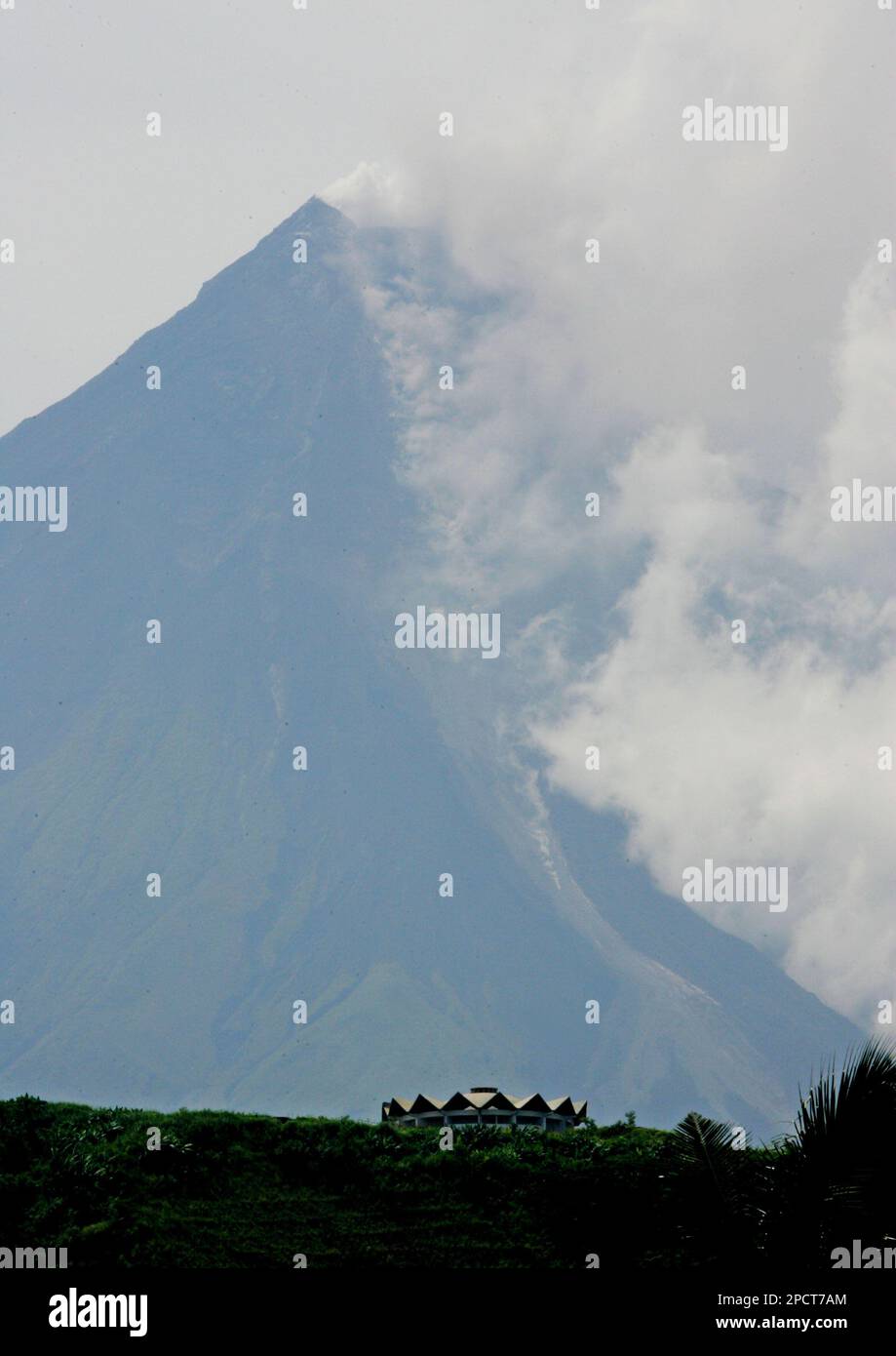 A cloud of grayish-brown lava fragments flows down the gully of Mayon ...