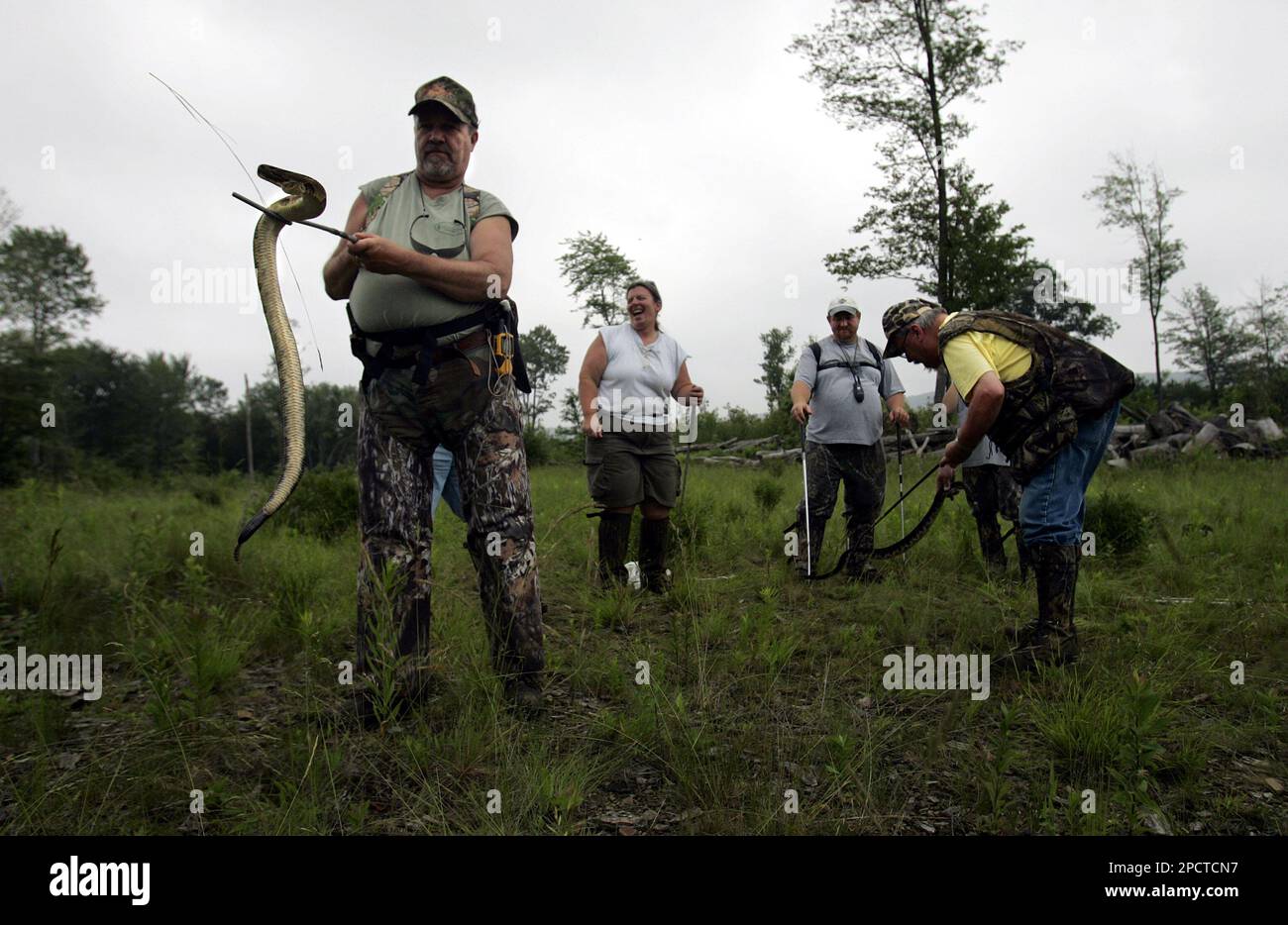 ** ADVANCE FOR SUNDAY JULY 16 ** Snake Hunter Tom Keller, left, uses a ...