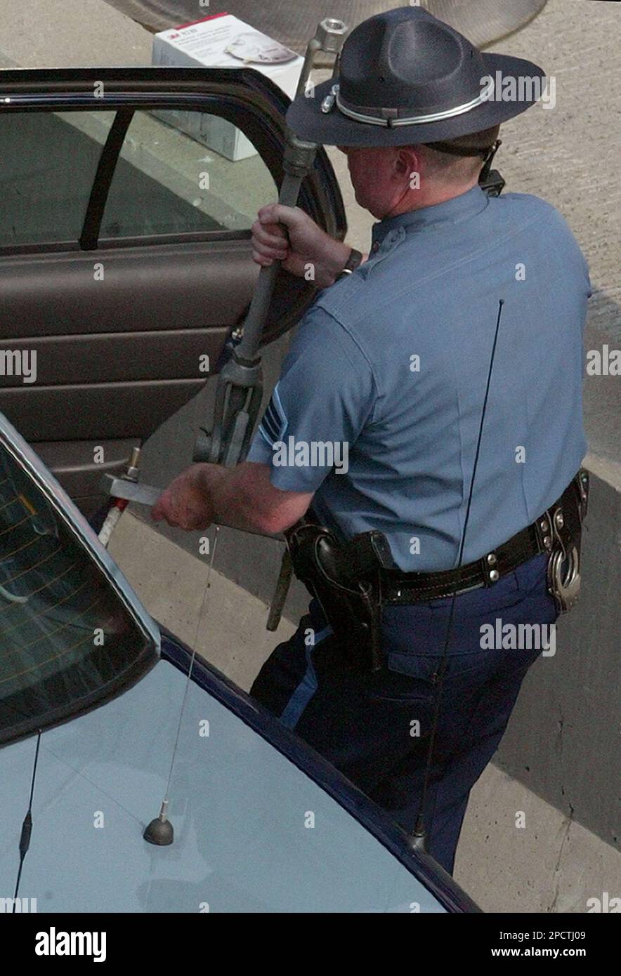 A Massachusetts State Trooper places into a police car Tuesday, July 11 ...