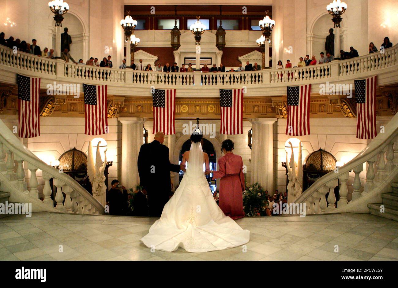 Bride Yenitza Ivetta Torres, center, is escorted by her parents Alberto ...