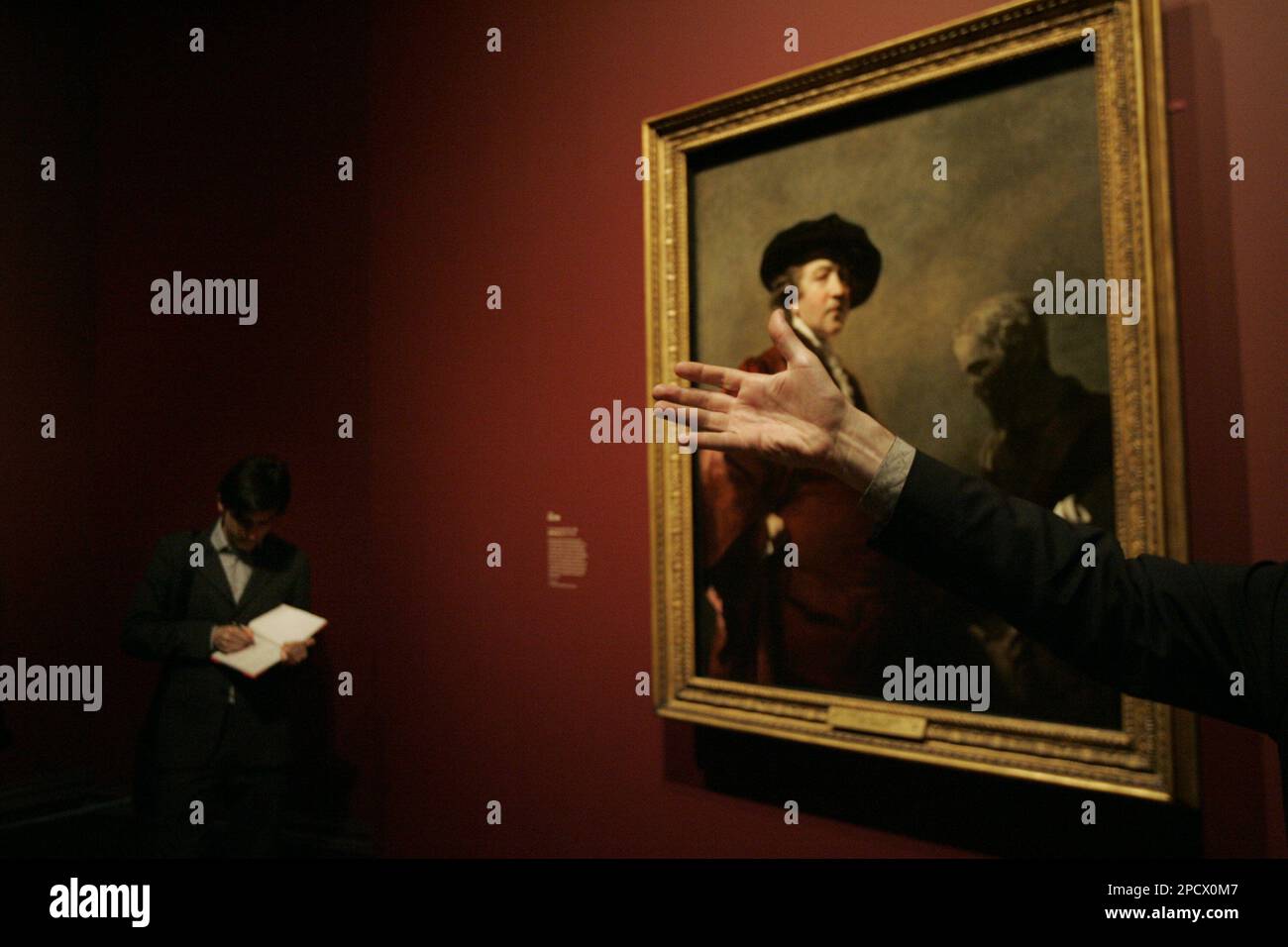 An art critic, left, takes notes as Alexander Sturgis, co-curator of ...
