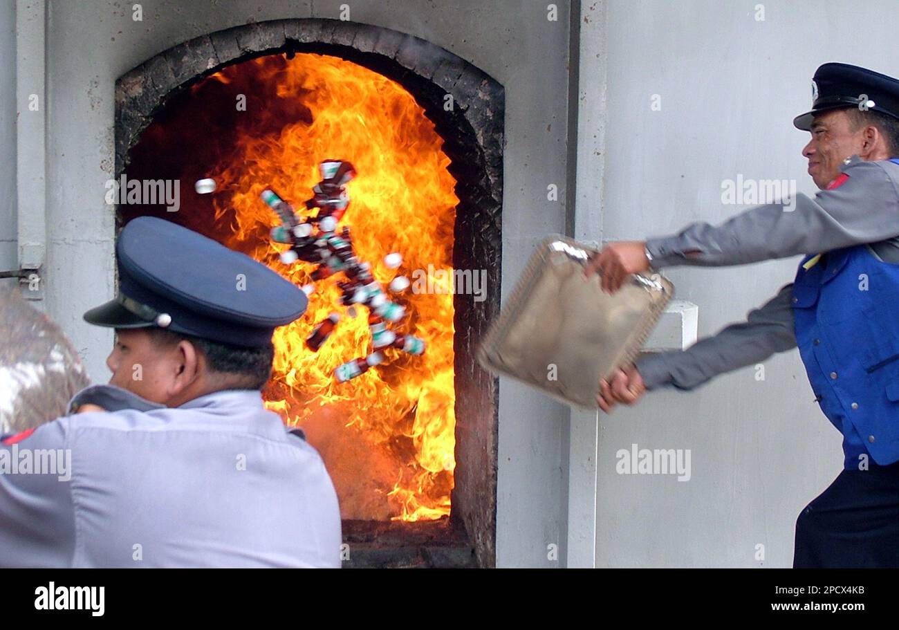 Myanmar government officials toss narcotic drugs into an incinerator ...