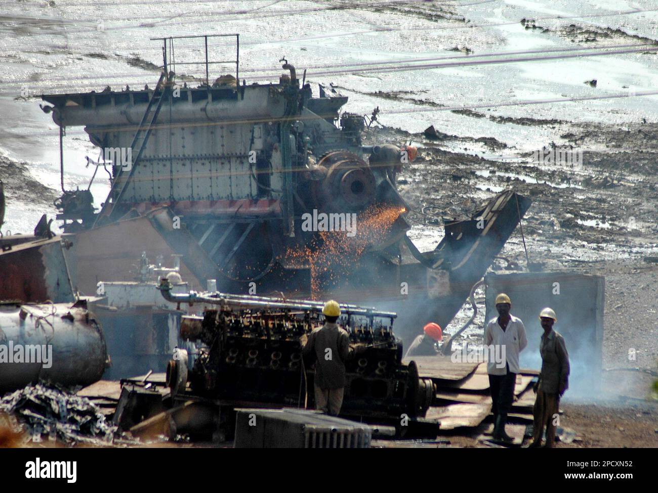 Workers dismantle a ship at a ship breaking yard in Alang, in the ...