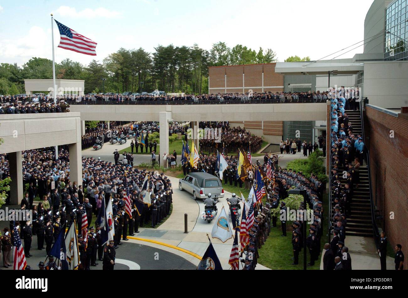 Fellow officers salute as the hearse carrying the casket of slain ...