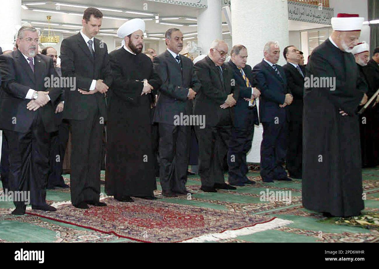 Syria's President Bashar Assad, second left, stands during prayers ...