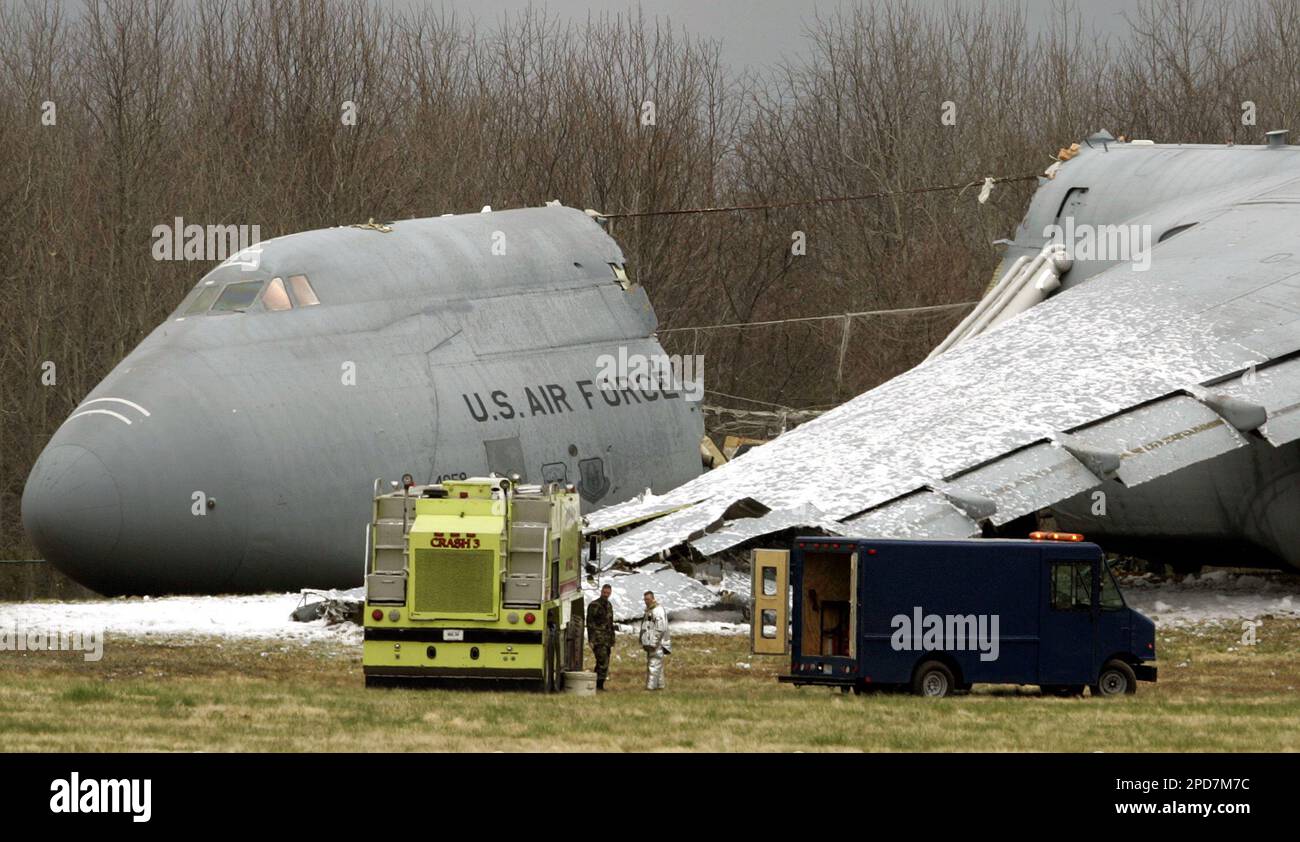 Air Force officials stand at their vehicles that are parked in front of ...