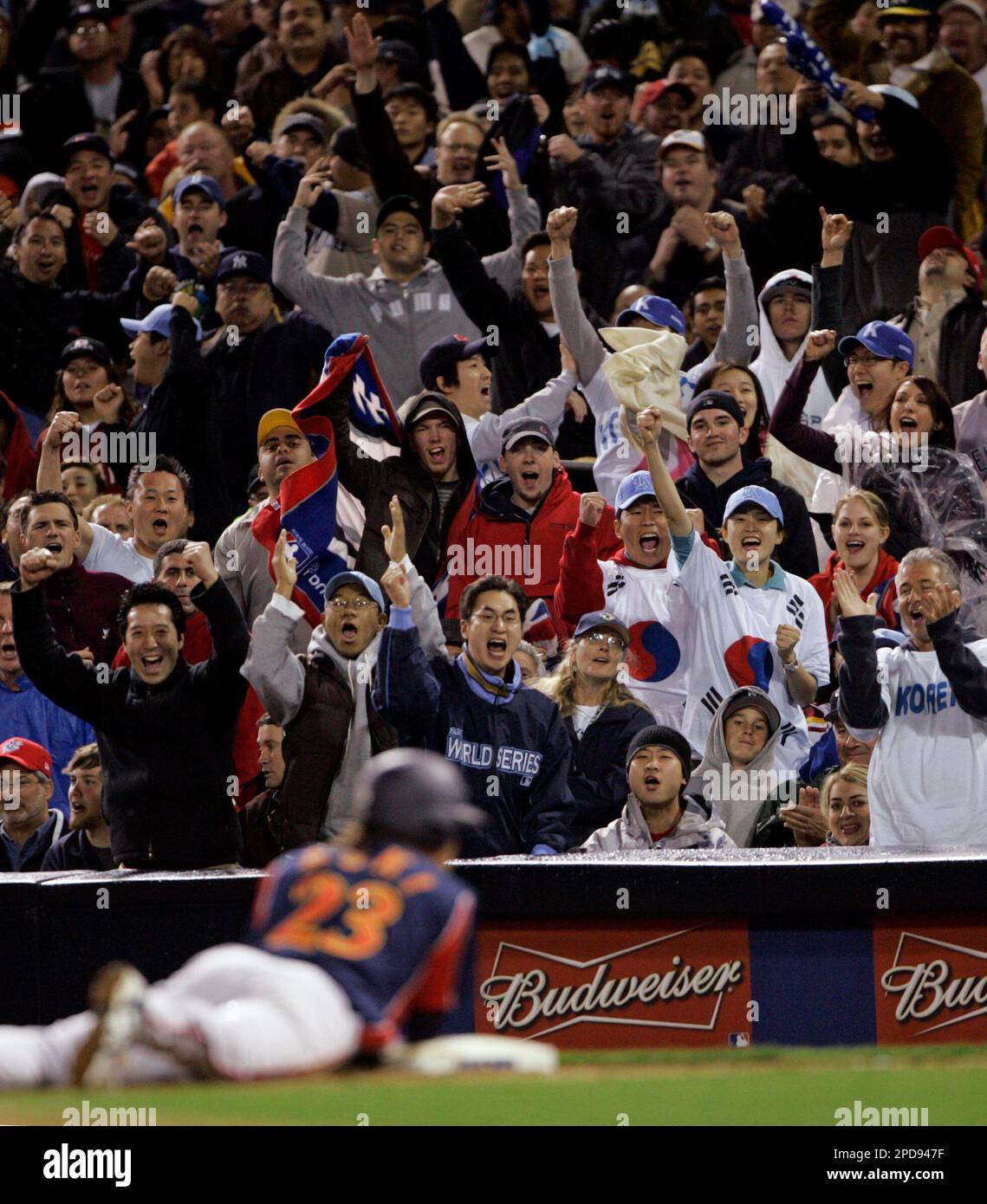 South Korea fans cheer as Japan's Norichika Aoki (23) is out at first ...