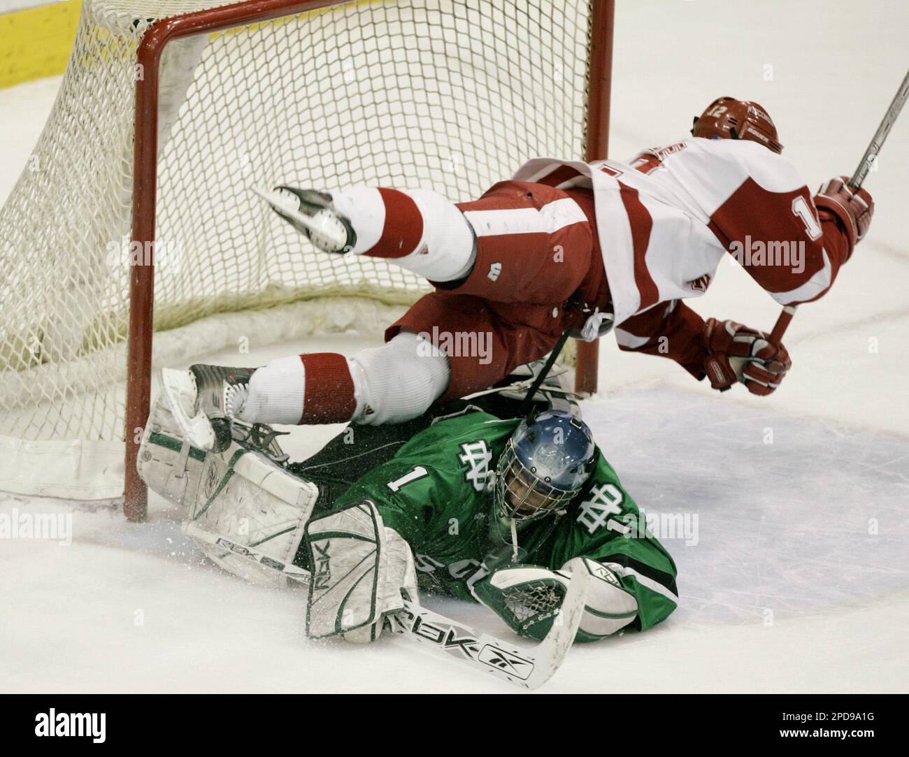 Wisconsin's Jack Skille, top, flips over North Dakota goalie Jordan ...