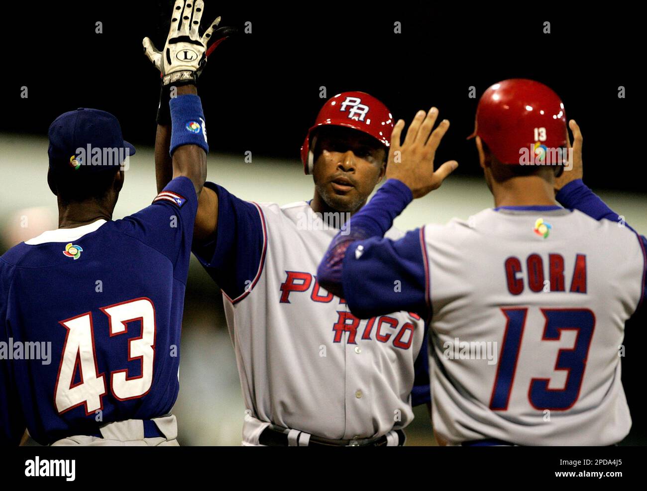 Team Puerto Rico's Bernie Williams, center, high-fives with teammate ...