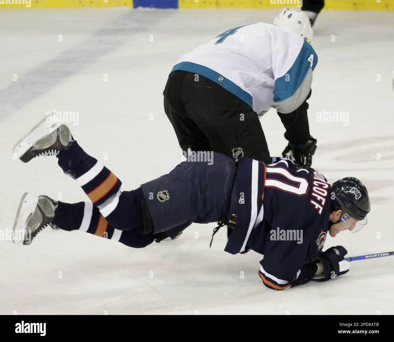 Edmonton Oilers' Shawn Horcoff falls to the ice after colliding with ...