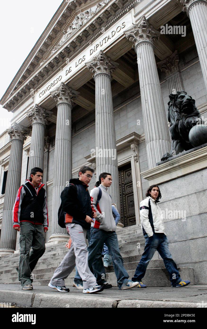A group of youths walk past the Spanish parliament in Madrid, Thursday ...