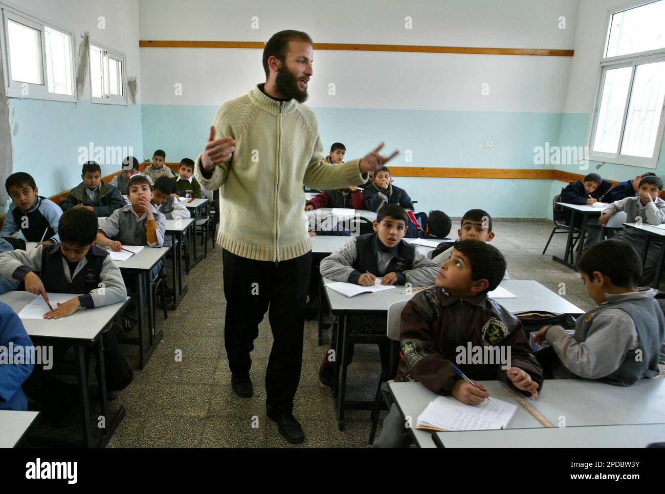 A teacher explains to Palestinian schoolboys during an Arab language ...