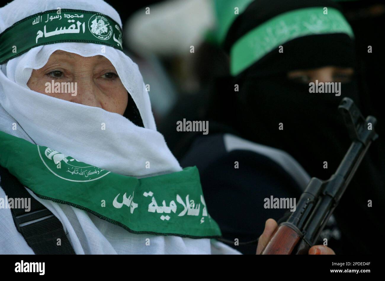 Palestinian female supporters of Islamic Hamas, one holding a machine ...