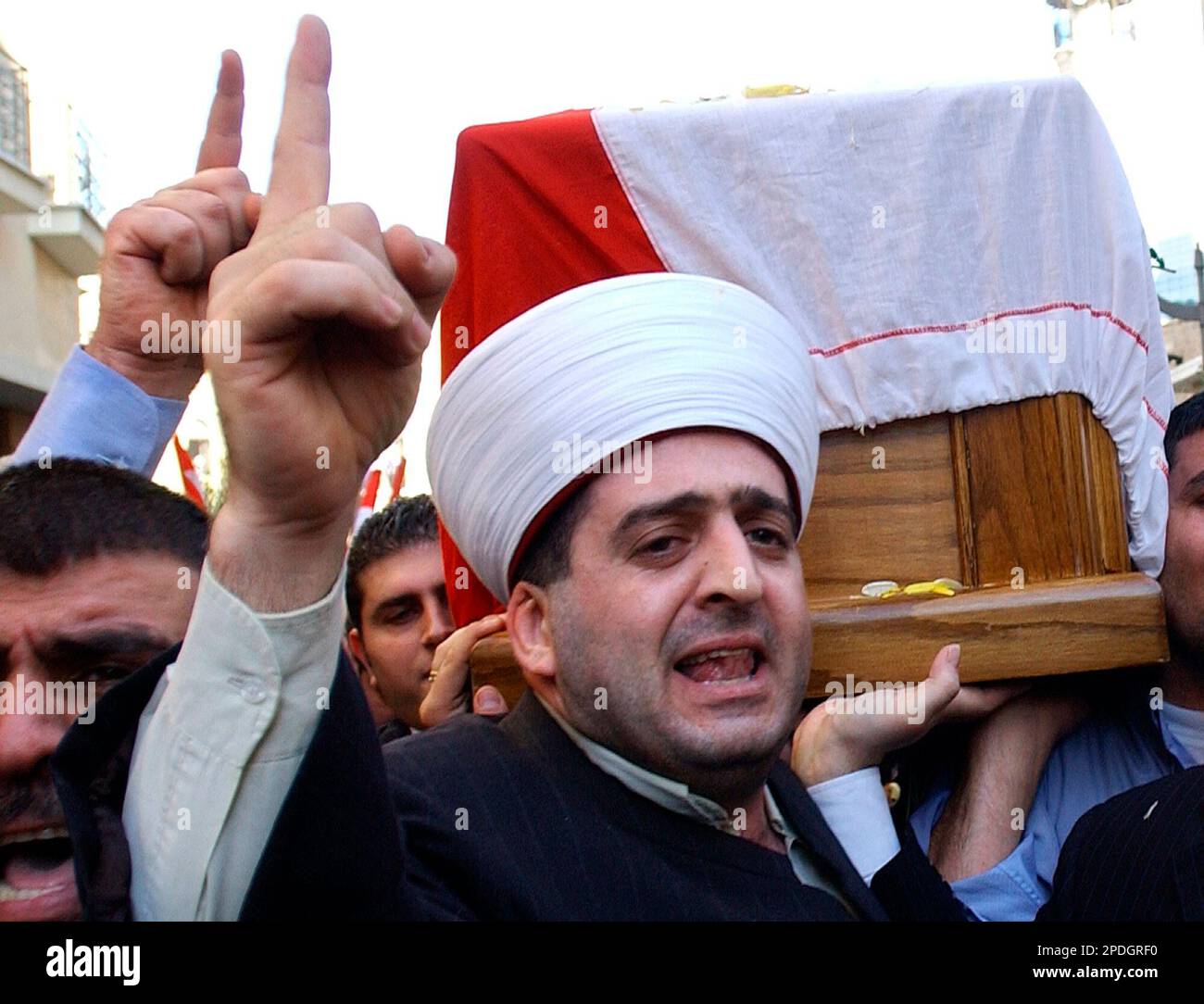 A Lebanese Muslim cleric shouts slogans while carrying the coffin of ...