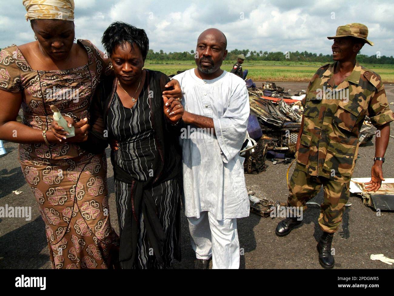 Ify Ilabor, center left, who lost her three children is consoled by ...