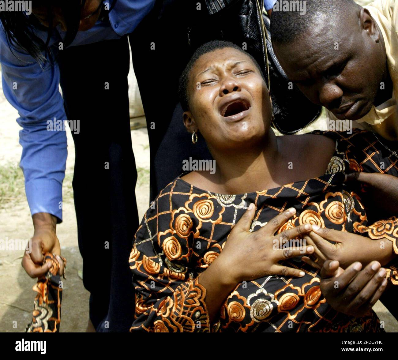 An unidentified woman, center, is consoled by relatives after she ...