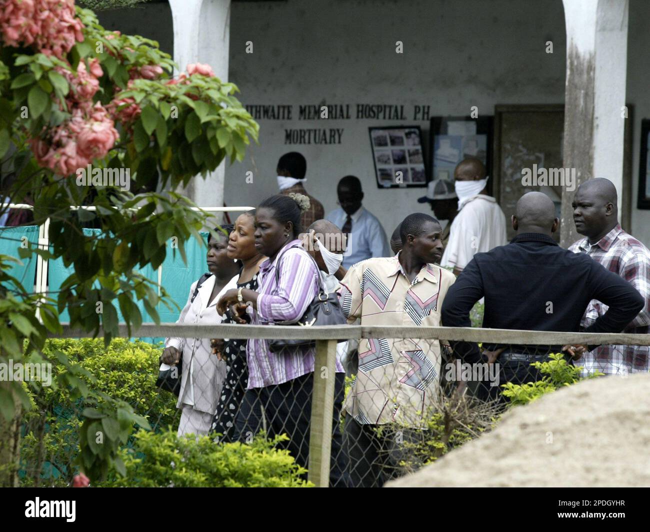 An unidentified woman, center left, is consoled by relatives after she ...