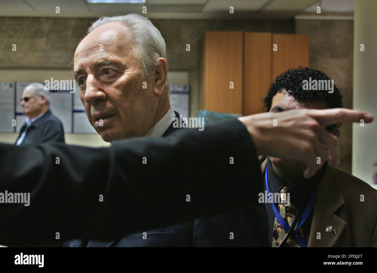An official shows the way to Israeli Vice Premier Simon Peres before ...