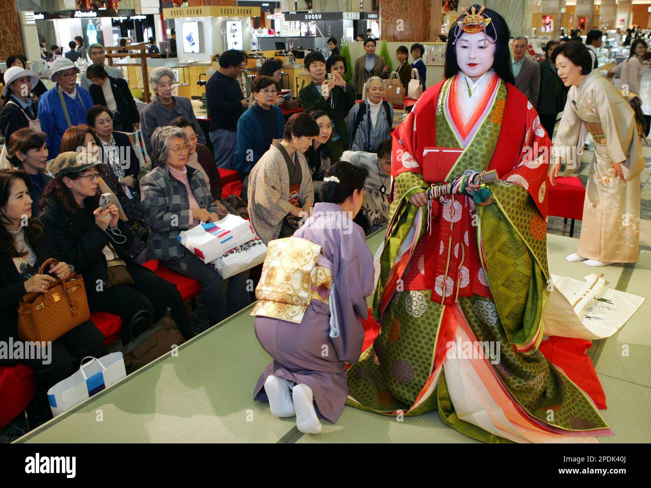 Shoppers at a Tokyo department store look at model Kazumi Hashimoto ...
