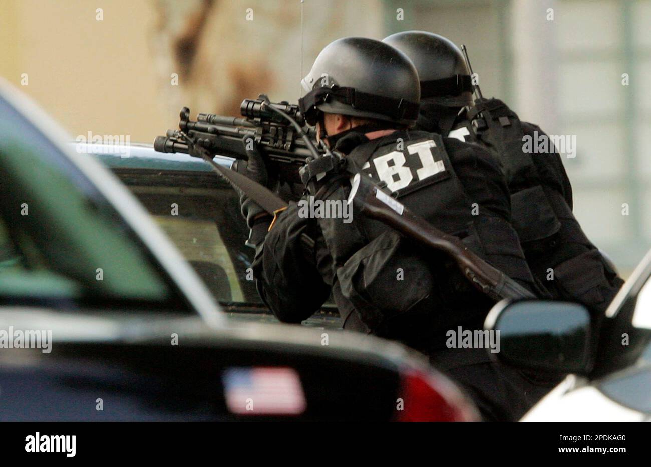 FBI agents stand ready with their weapons during a raid Thursday, Nov ...