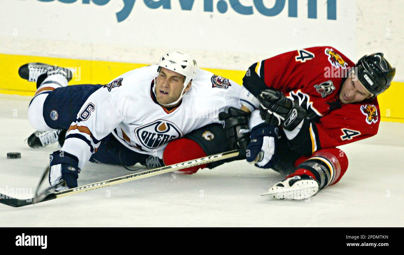 Calgary Flames' Roman Hamrlik , right, takes a penalty for hauling down ...