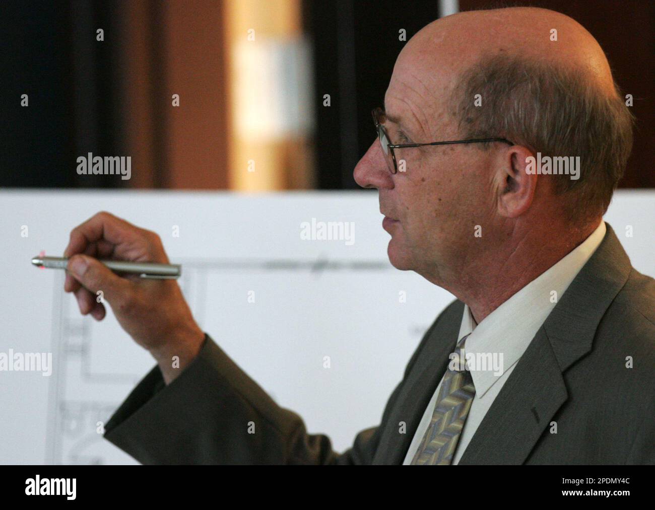 Defense ballistics expert Larry Dehus uses a laser pen to identify ...